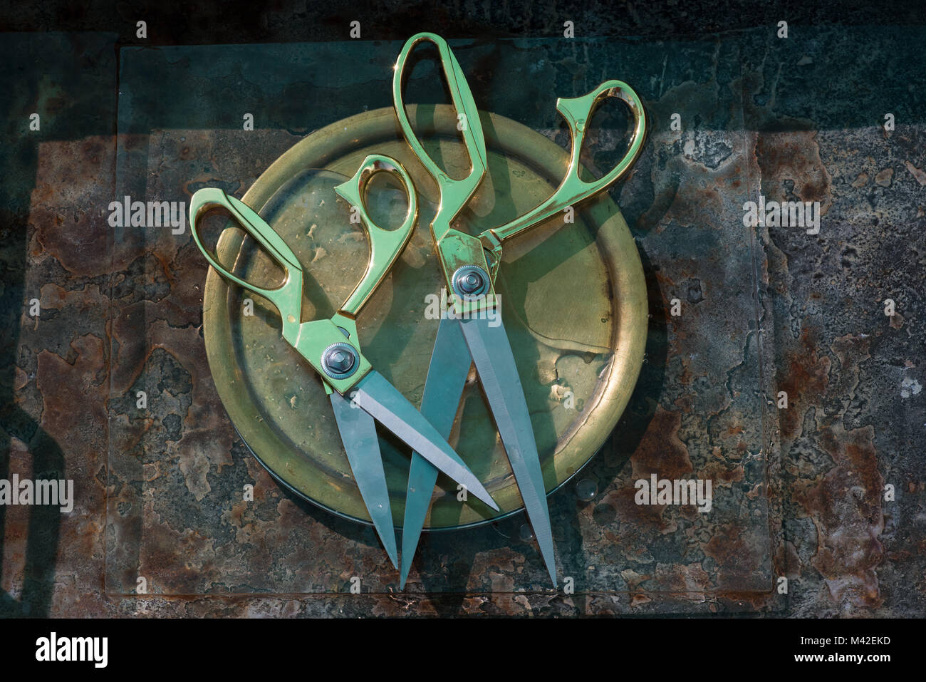 Two identical in shape scissors and different in size lie side by side ...