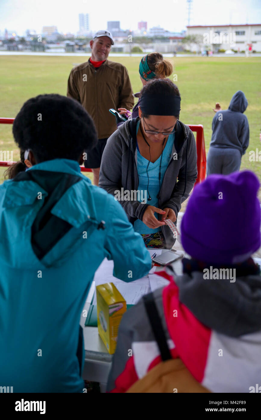 CAMP FOSTER, OKINAWA, Japan – A runner signs in and receives her ...