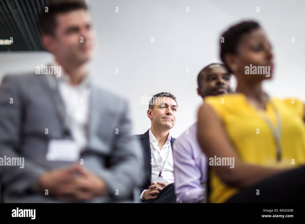 Businessman listening to a motivational speaker Stock Photo - Alamy