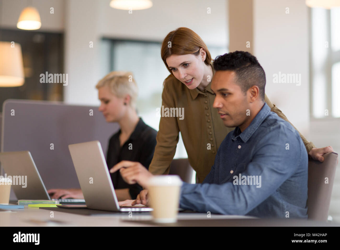 Manager training new employee in office Stock Photo - Alamy