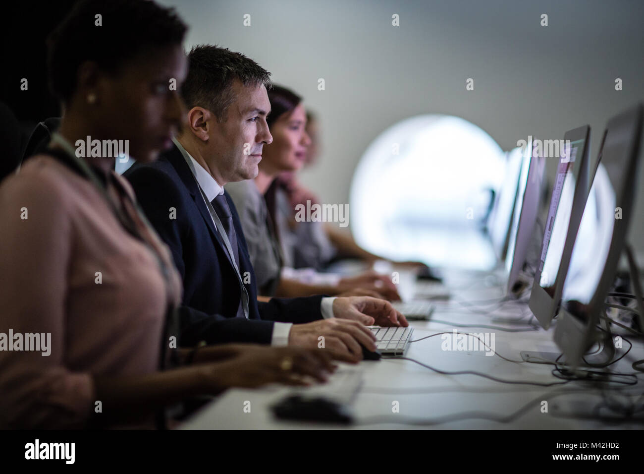 Businessman using computer in crowded office Stock Photo - Alamy