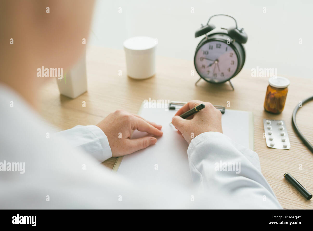 Female doctor writing notes, patient's medical history or medicine ...