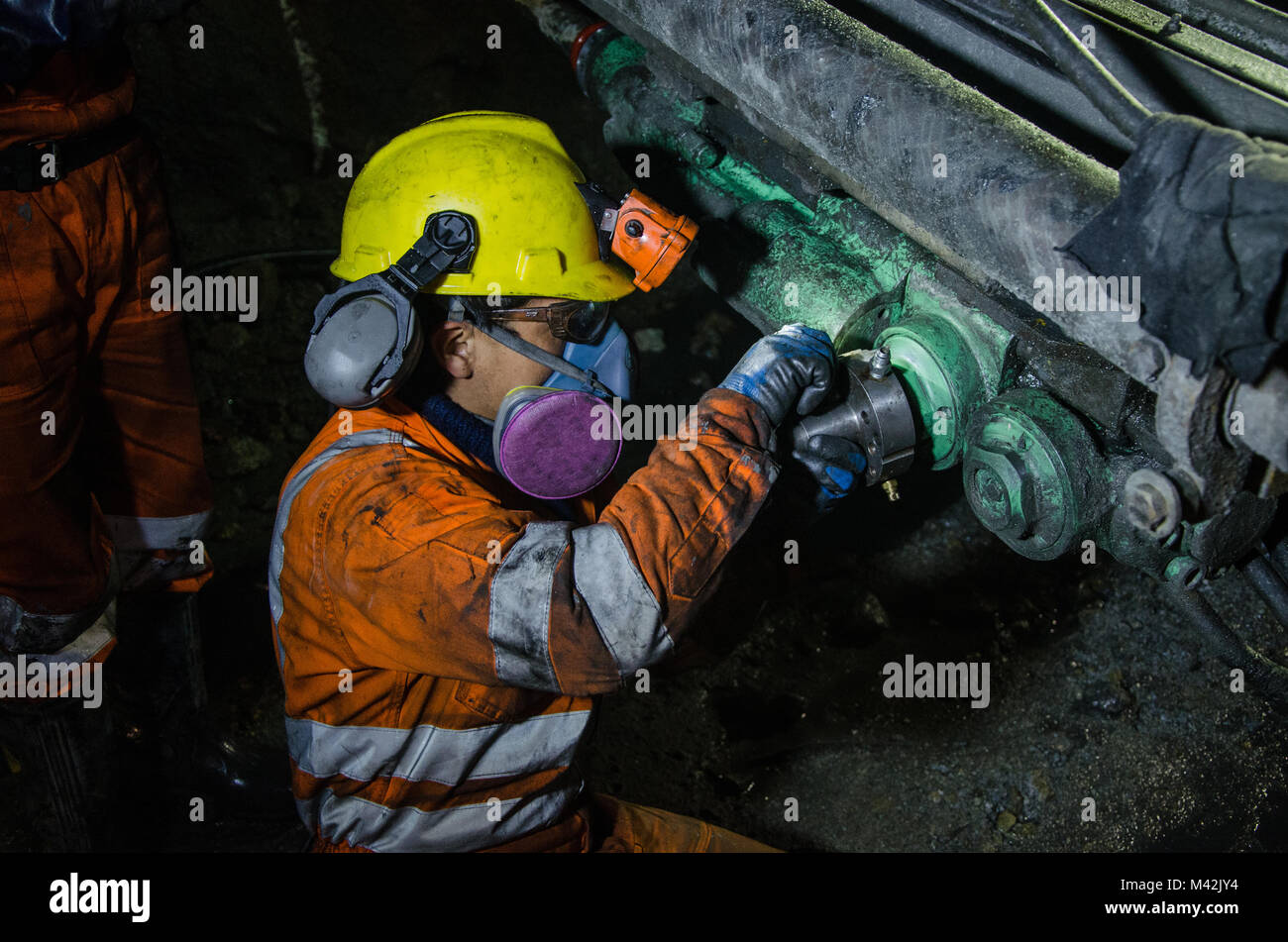 Miner fixing mineral extraction machine Stock Photo - Alamy