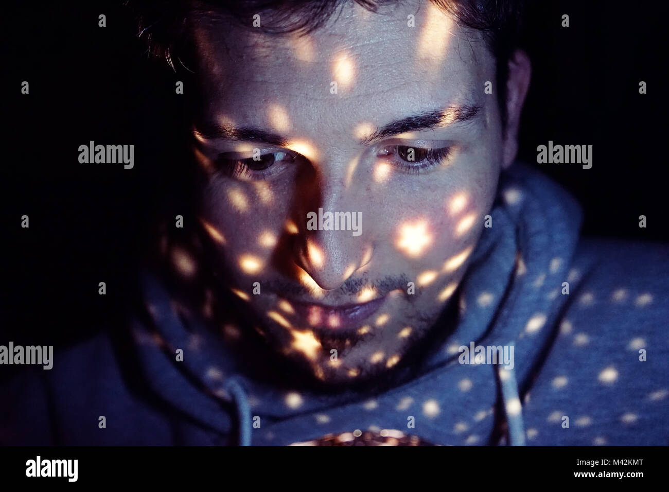 Young man illuminated by a light projector Stock Photo - Alamy