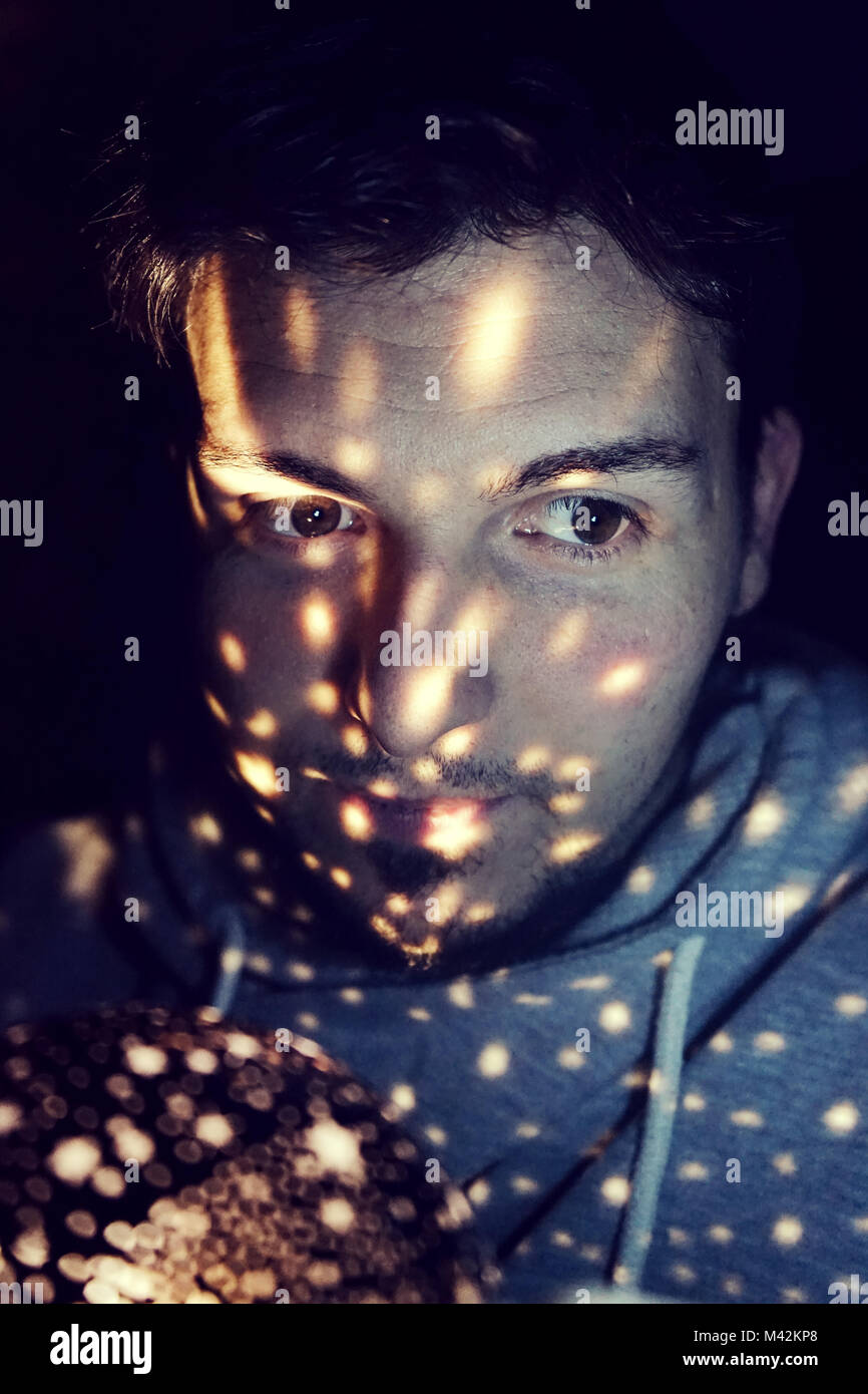 Young man illuminated by a light projector Stock Photo - Alamy