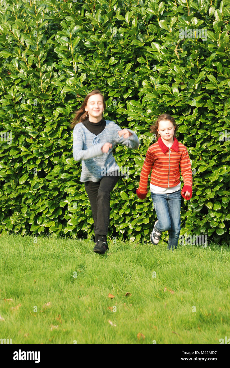 Girls running in the garden Stock Photo - Alamy