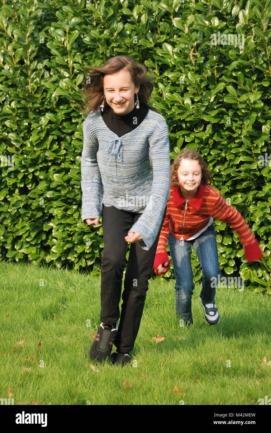 Girls running in the garden Stock Photo - Alamy