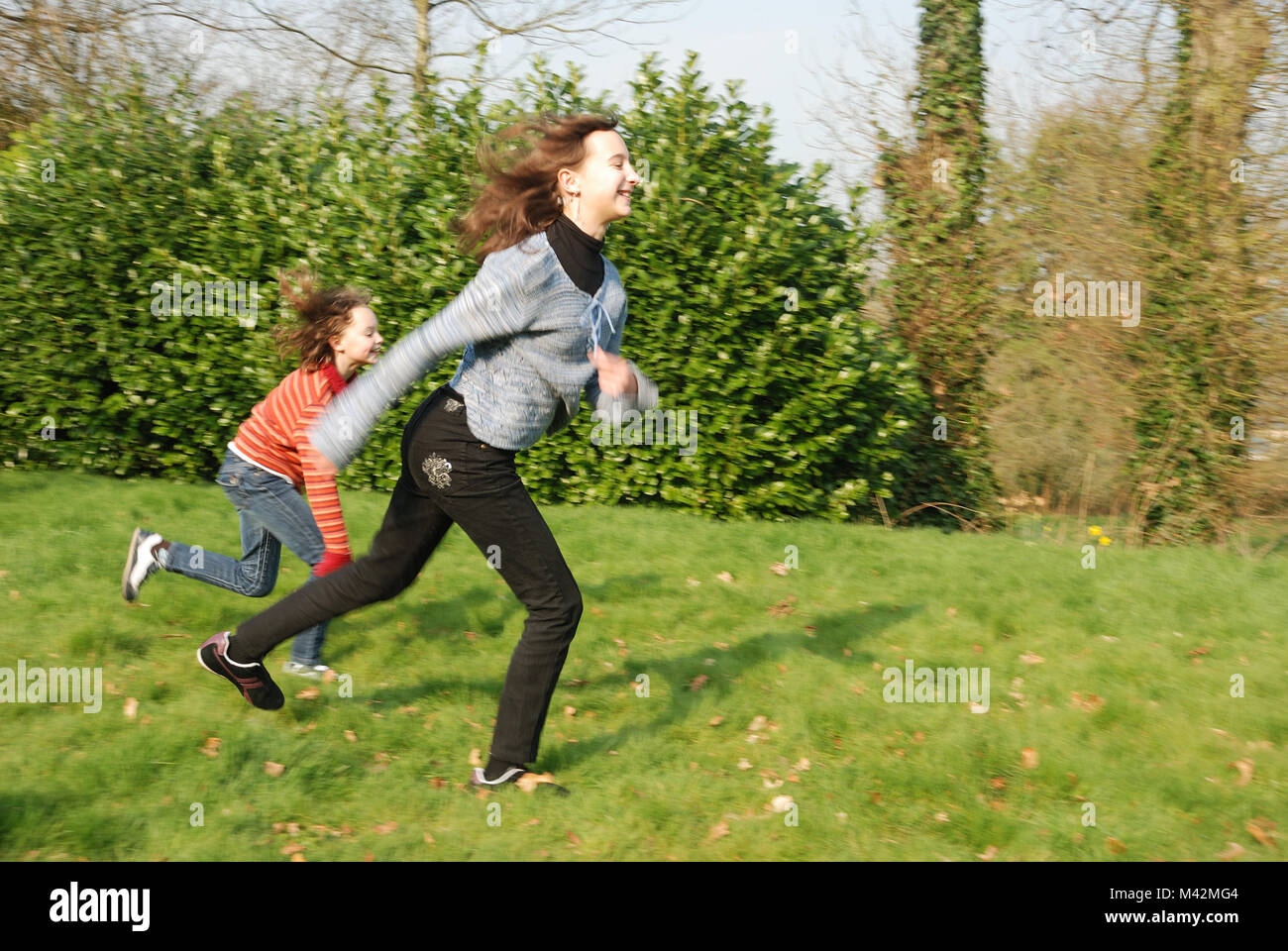 Girls running in the garden Stock Photo - Alamy