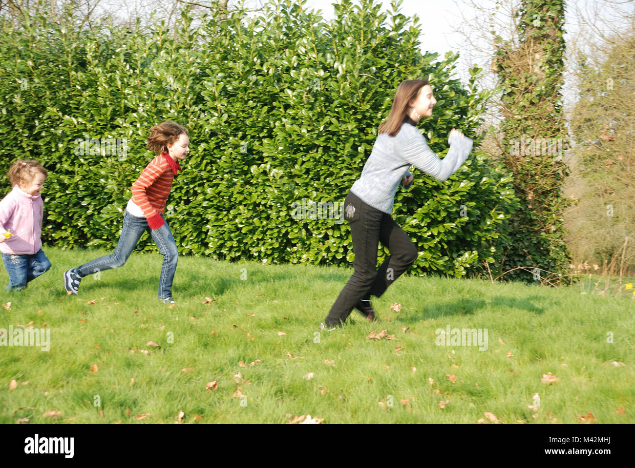 Girls running in the garden Stock Photo - Alamy