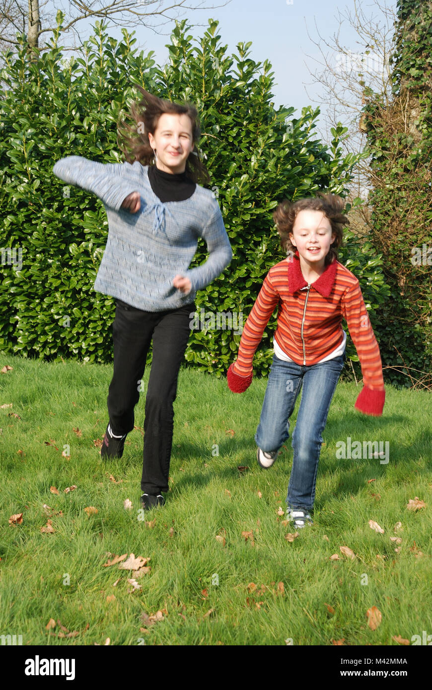 Girls running in the garden Stock Photo - Alamy