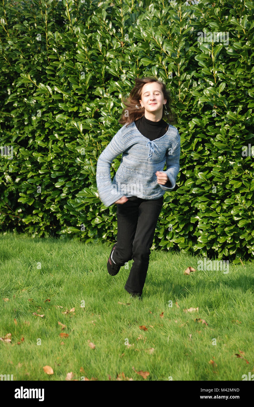 Girl running in the garden Stock Photo - Alamy