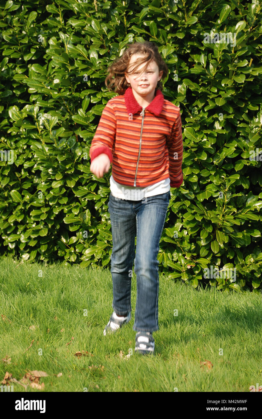 Girl running in the garden Stock Photo - Alamy