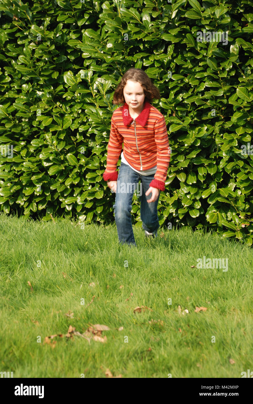 Girl running in the garden Stock Photo - Alamy