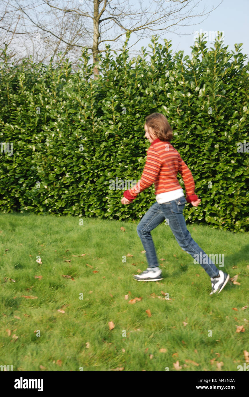Girl running in the garden Stock Photo - Alamy