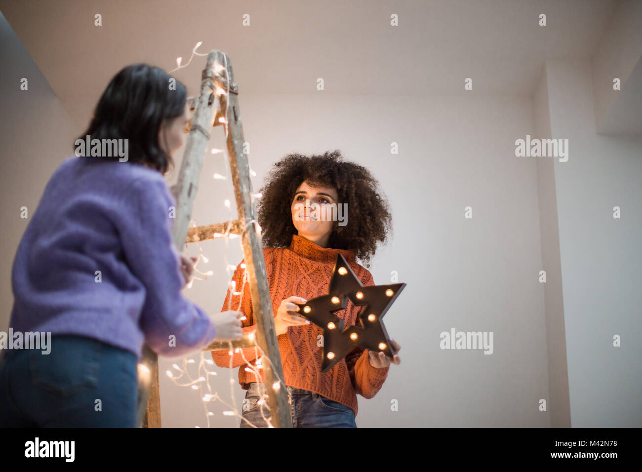 Friends decorating an alternative christmas tree Stock Photo - Alamy