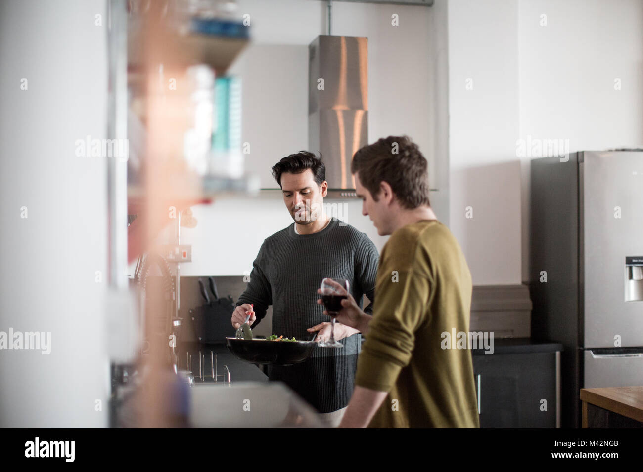Young male couple cooking in kitchen Stock Photo - Alamy