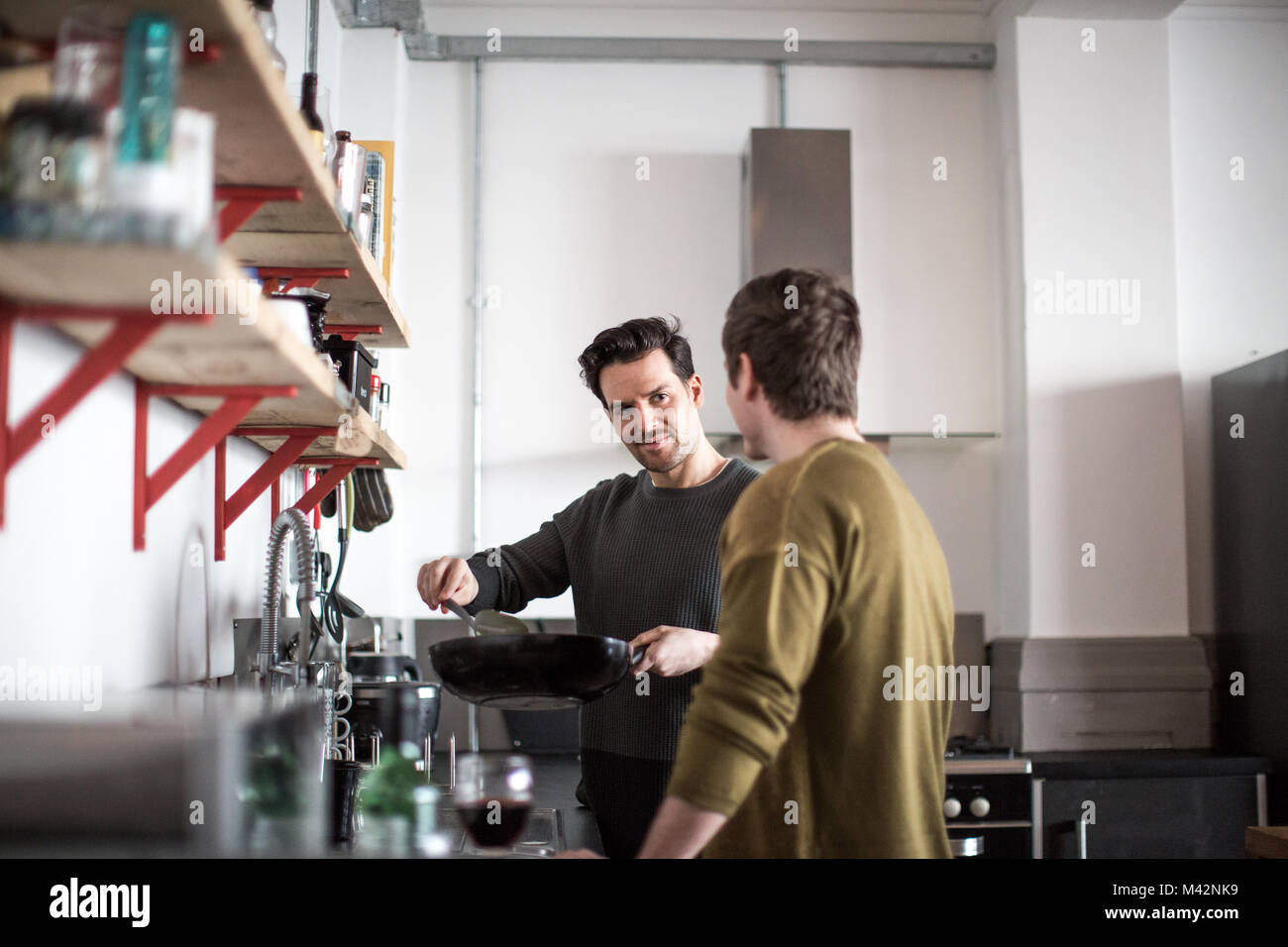 Young male couple cooking in kitchen Stock Photo - Alamy