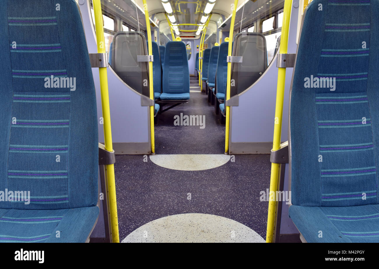 the inside of a railway carriage with blue seats in rows or lines and ...