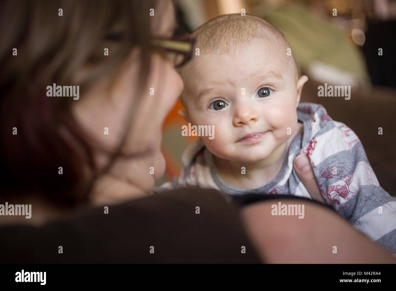 a newborn baby shares a smile as it snuggles with its mother Stock ...