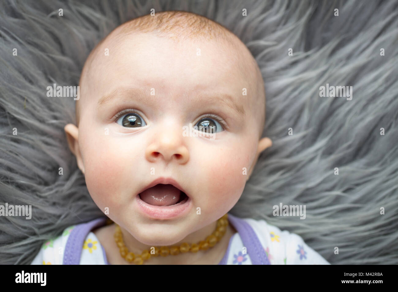 A newborn baby shares a smile as it stares up from a pillow Stock Photo ...