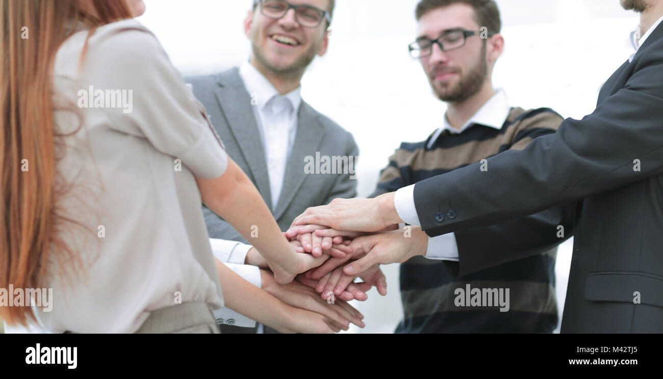 Business team standing joining hands together Stock Photo - Alamy