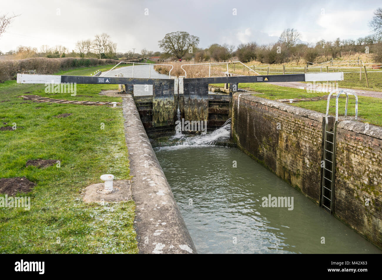 Water gushing through a canal lock with balance beams at the Kennet and ...