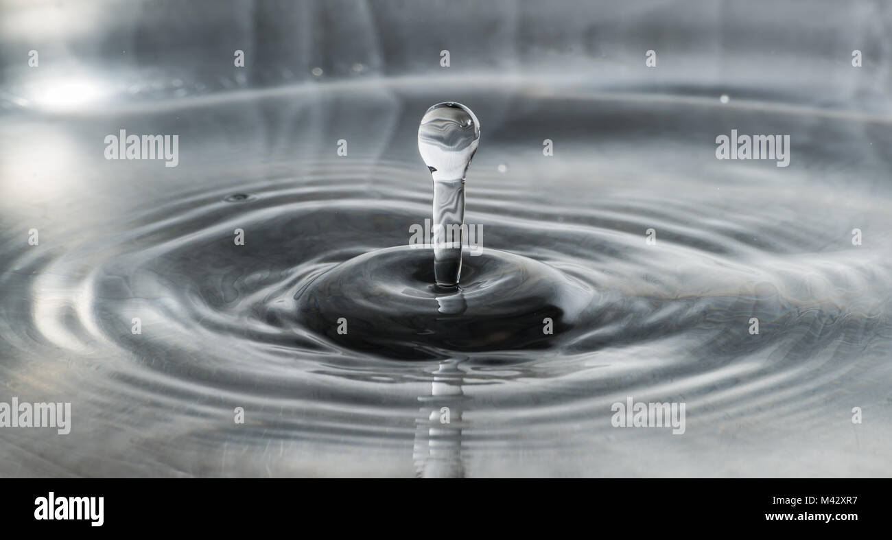 Water drop falling into water making a concentric circles Stock Photo ...