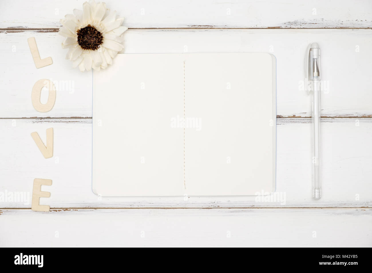 Top view open notebook, pencil and love word calligraphy on white ...