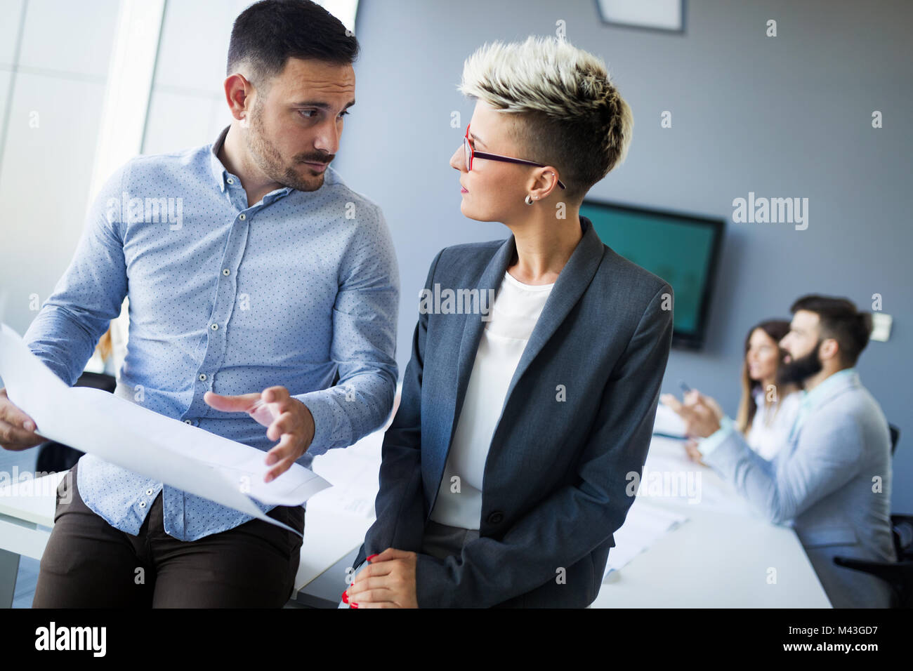 Picture of business colleagues talking in office Stock Photo - Alamy