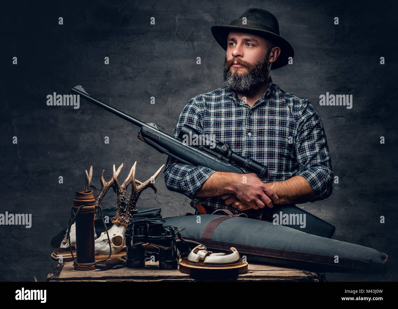 Bearded traditional hunter with his trophy holds a rifle Stock Photo ...