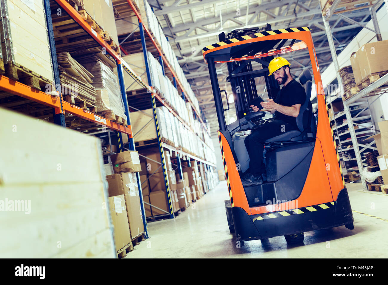 Warehouse worker doing logistics work with forklift loader Stock Photo ...