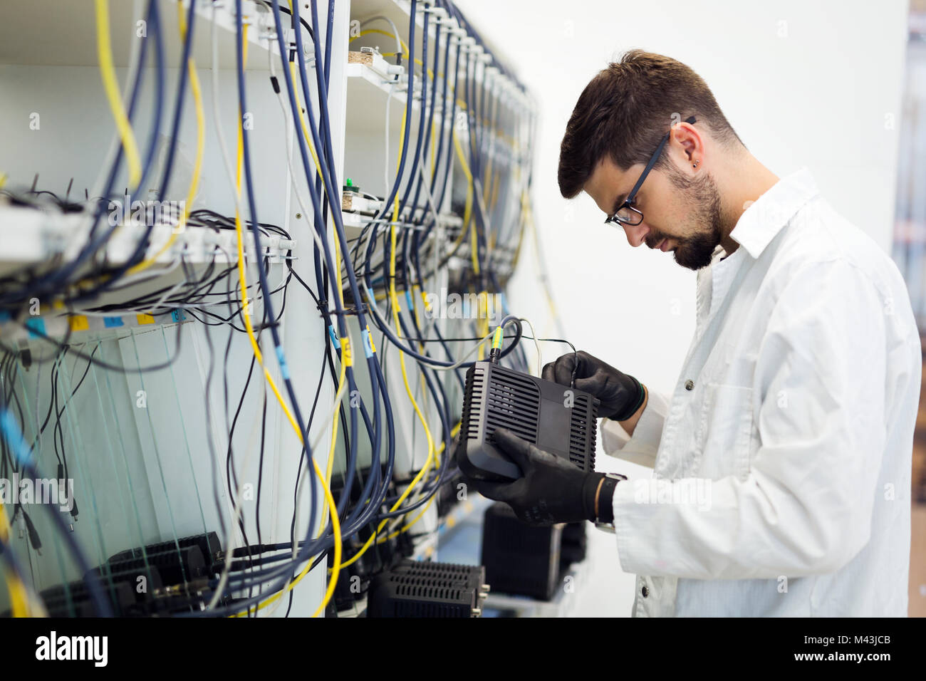 Picture of network technician testing modems in factory Stock Photo - Alamy