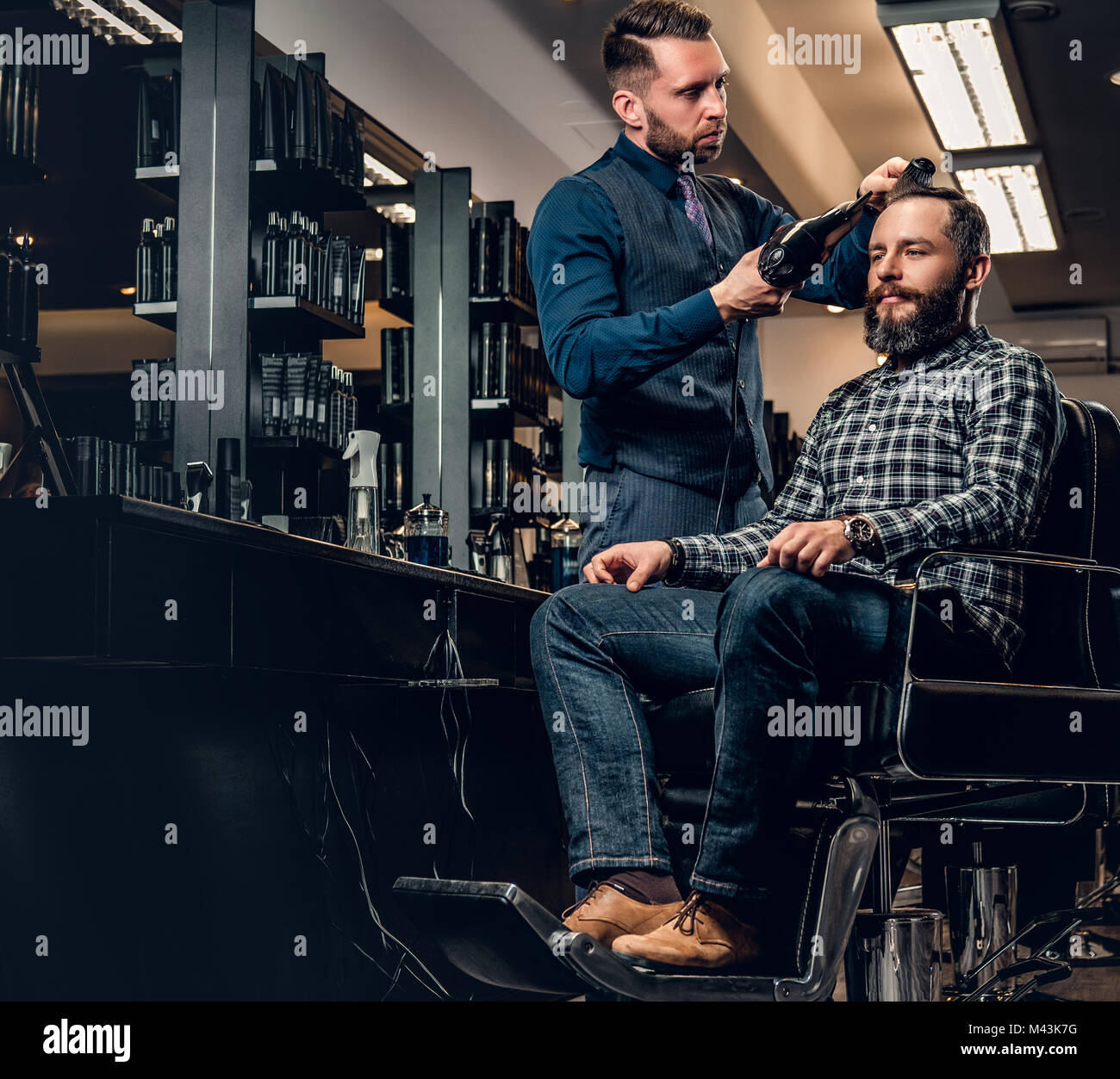 Hairdresser drying man's hair with hairdryer in a saloon Stock Photo ...