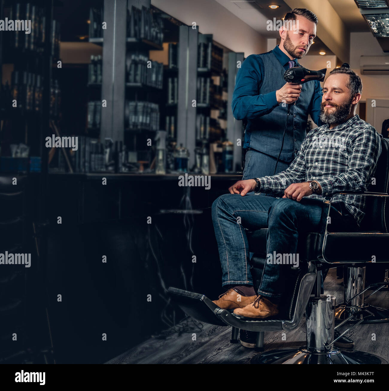 Hairdresser drying man's hair with hairdryer in a saloon Stock Photo ...