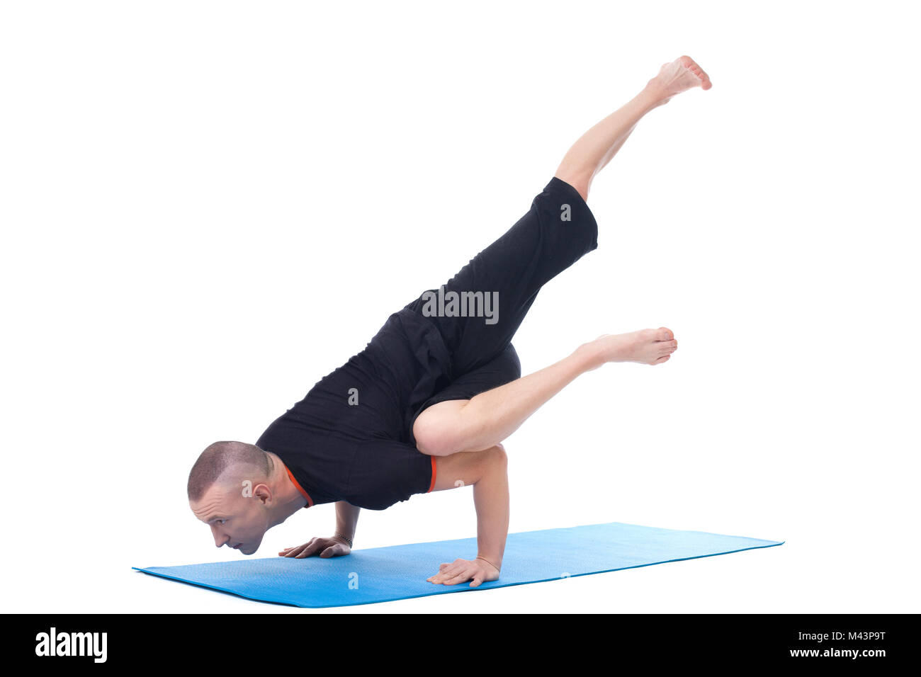 Concentrated yogi doing difficult asana in studio Stock Photo - Alamy