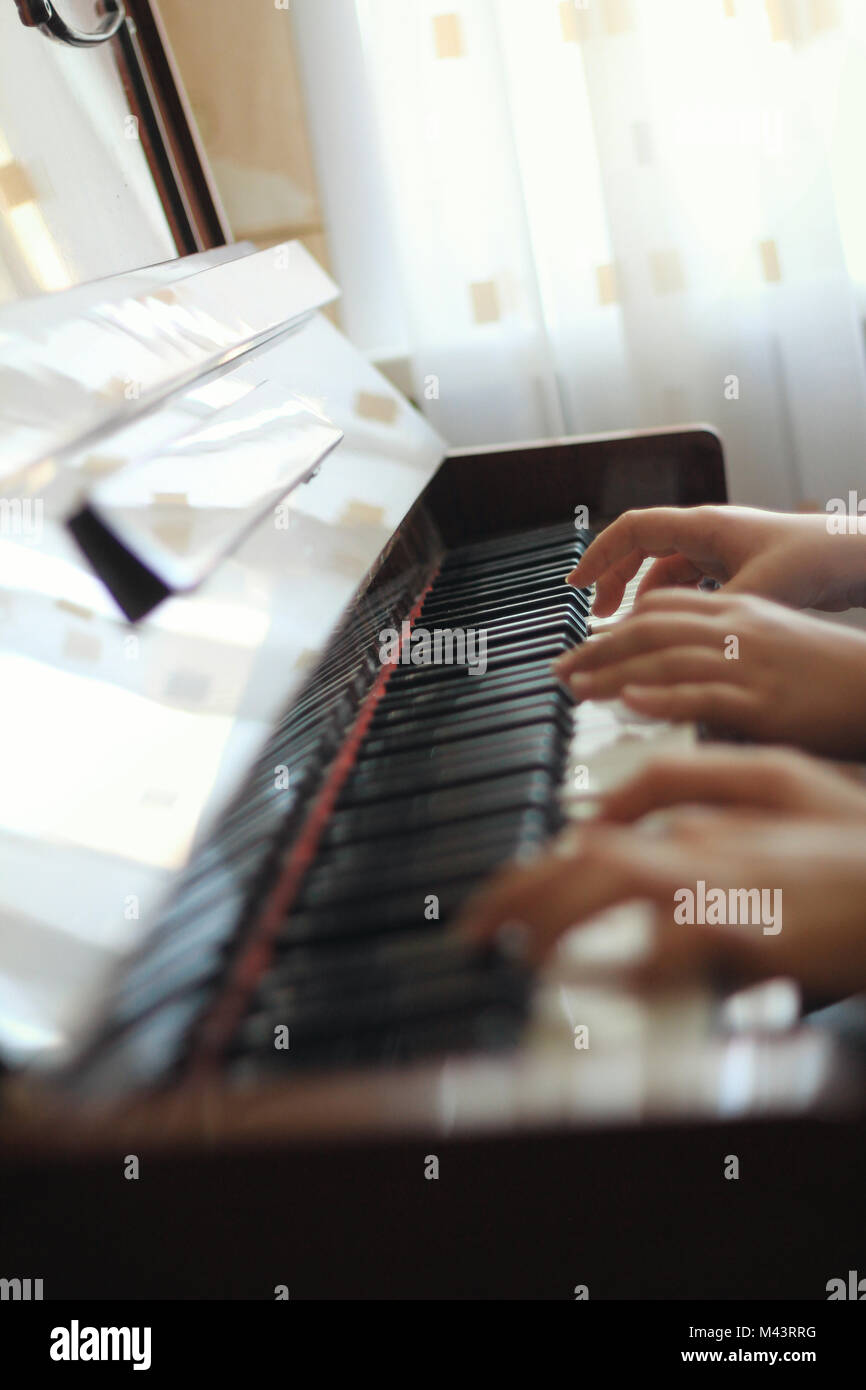 Two hands of teenagers plays on piano - musicial concept Stock Photo ...