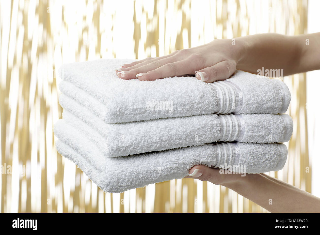 Female hands holding a pile of white towels Stock Photo - Alamy