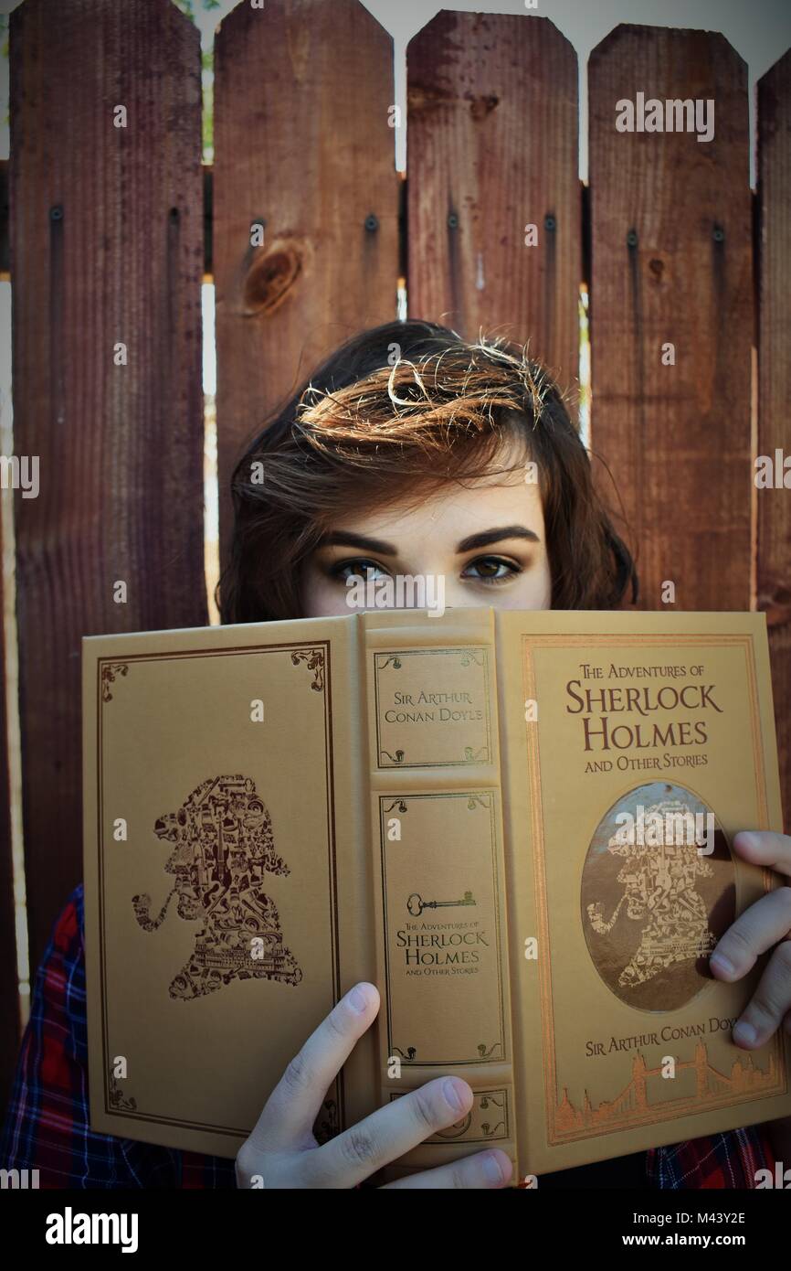 Young Women Dramatically Looking At The Camera Holding Mystery Book ...