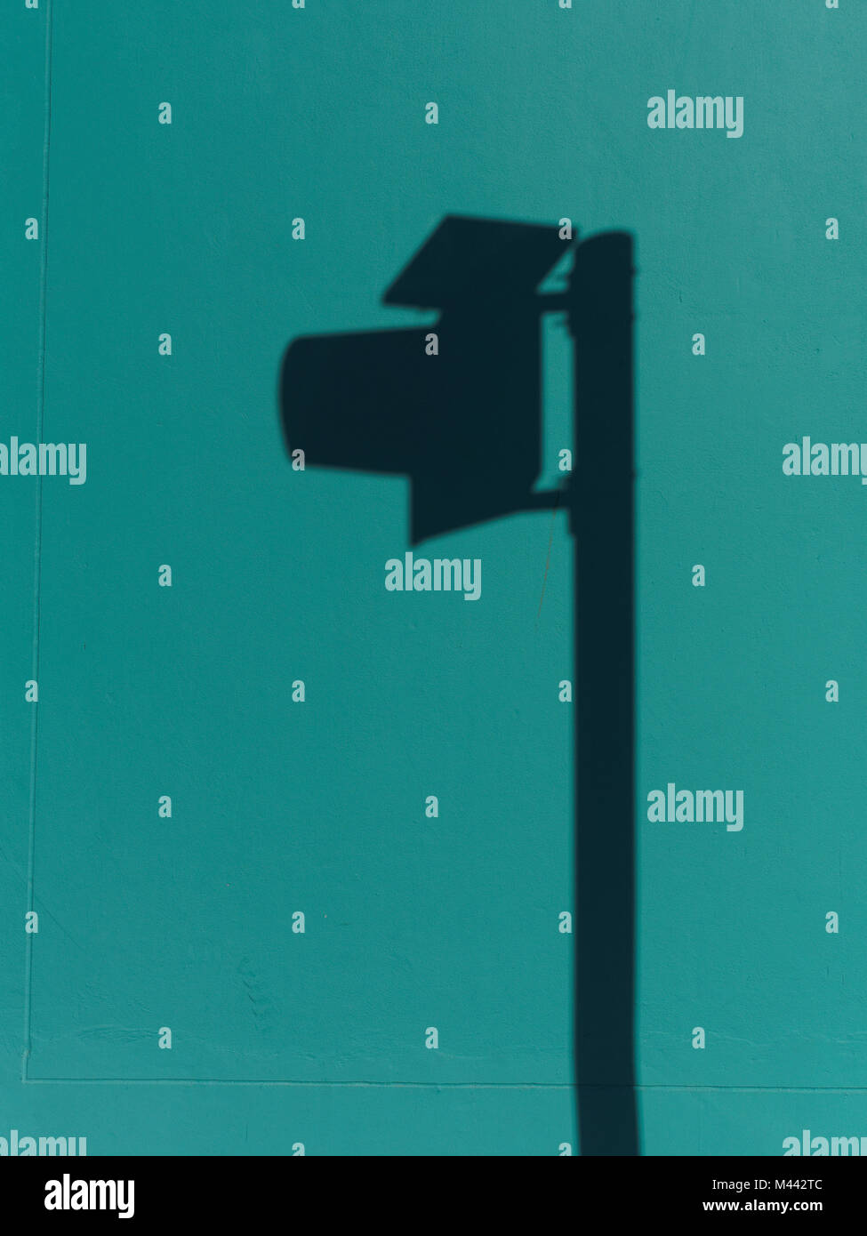 Shadow of traffic light pole on greenery painted wall background used ...