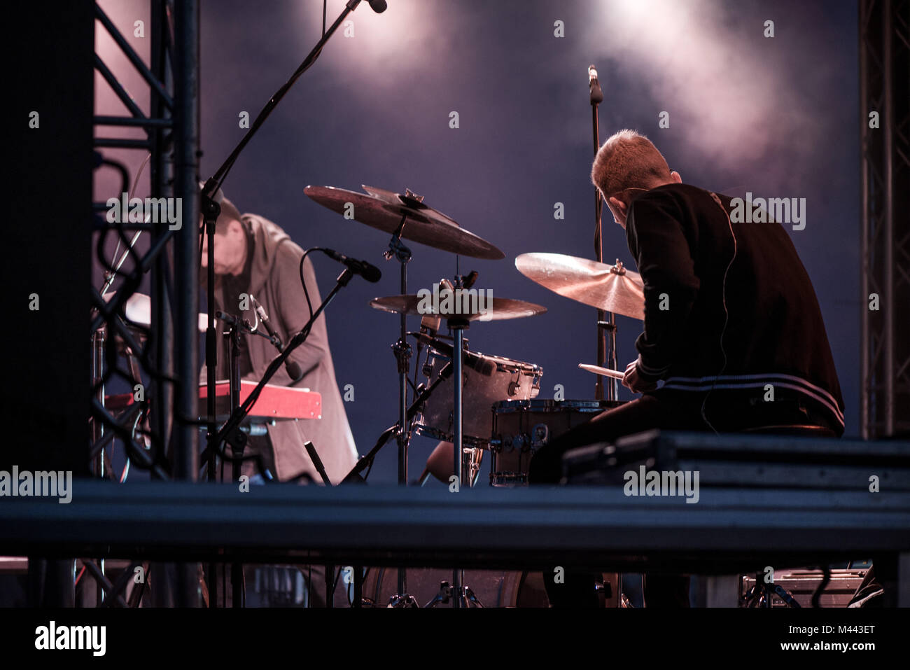 Artist playing on keyboard synthesizer piano keys, man playing drums on ...