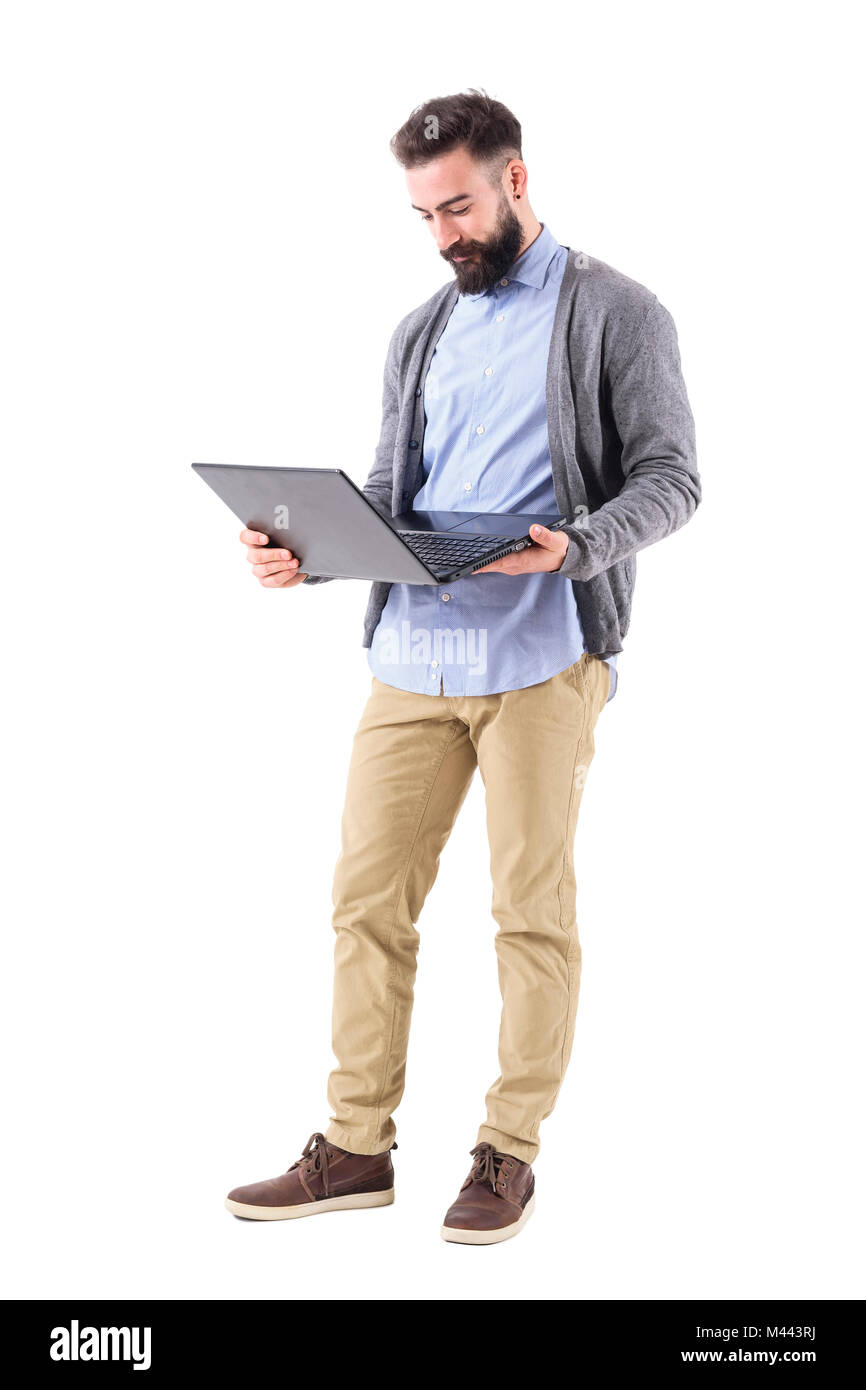 Relaxed smiling businessman holding and watching at laptop computer ...