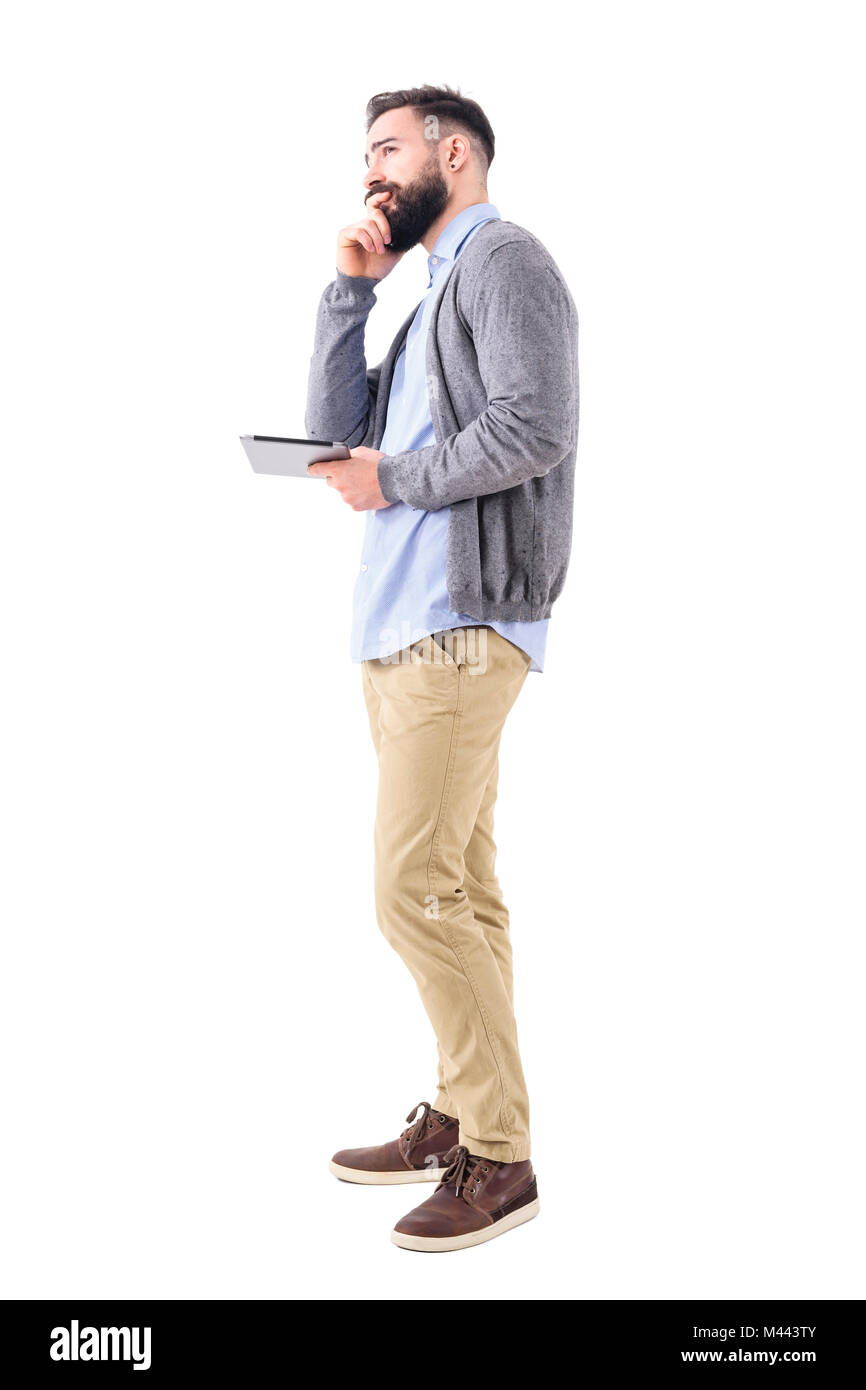 Young adult business man with tablet thinking and looking up. Full body ...