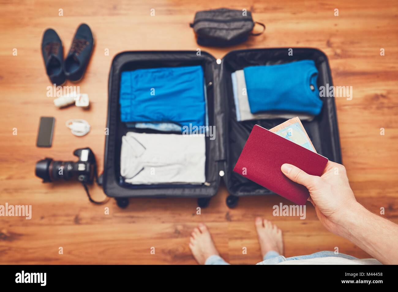 Preparing luggage for the trip. Young man packing vacation items ...
