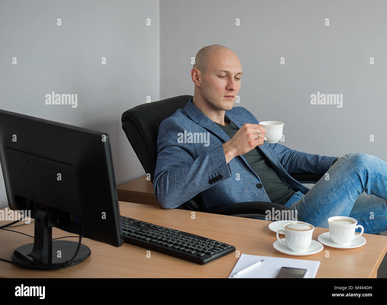 Businessman drinking coffee in office Stock Photo - Alamy