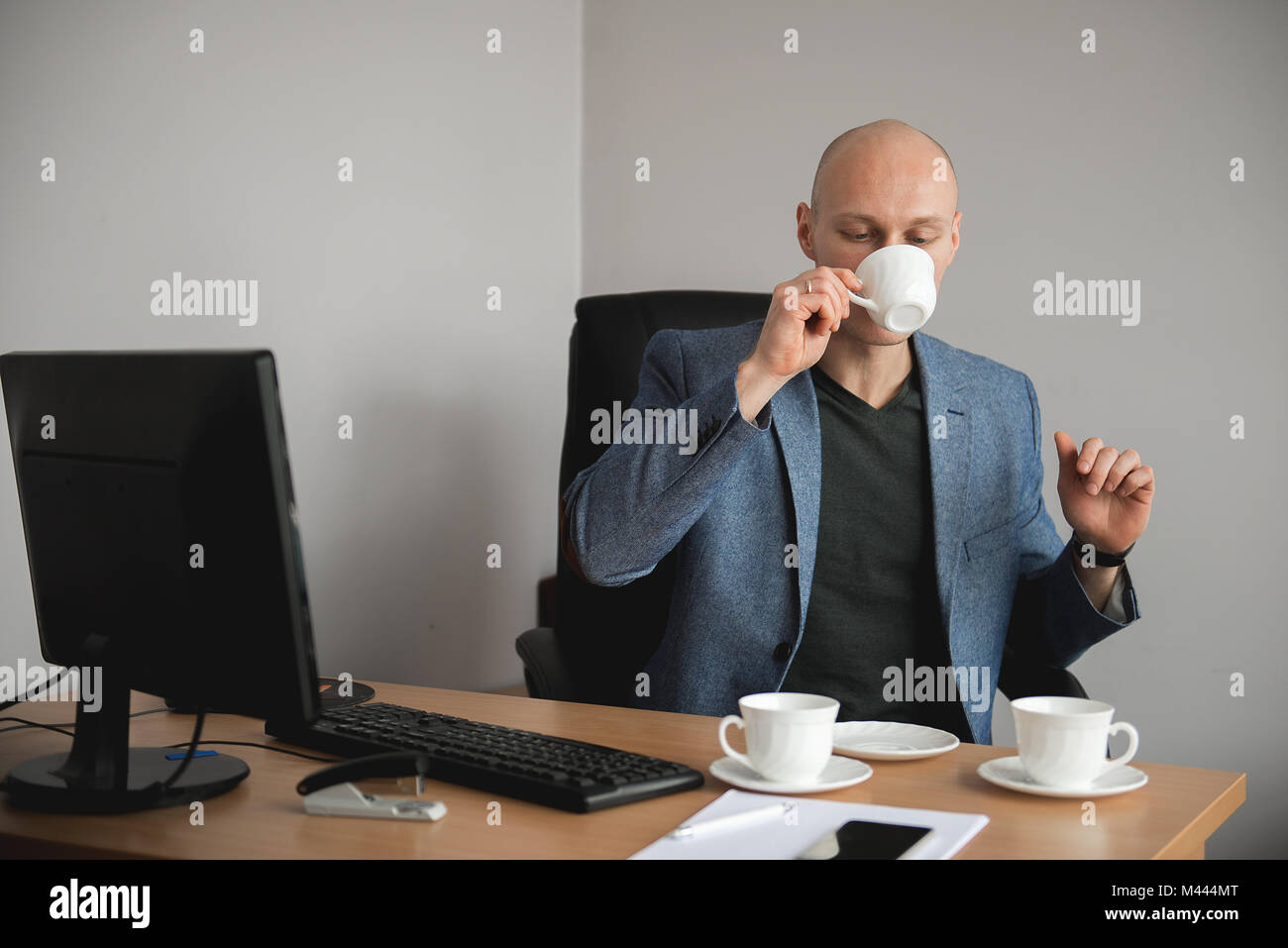 Businessman drinking coffee in office Stock Photo - Alamy