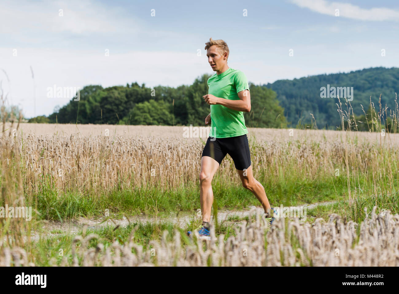 Young male runner running along rural dirt track Stock Photo - Alamy