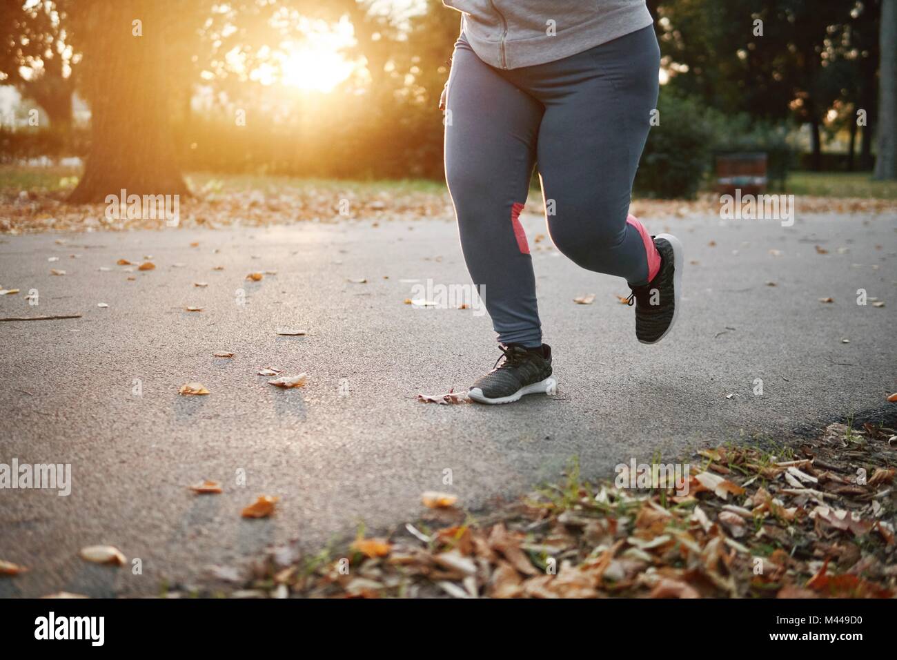 Curvaceous young female runner running in park, waist down Stock Photo ...