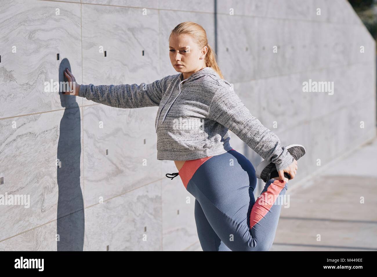 Curvaceous young woman training, stretching leg Stock Photo - Alamy