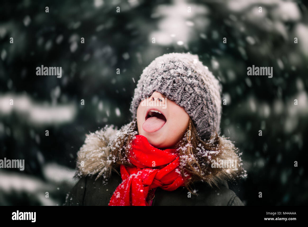 Portrait of girl catching falling snow on tongue Stock Photo - Alamy