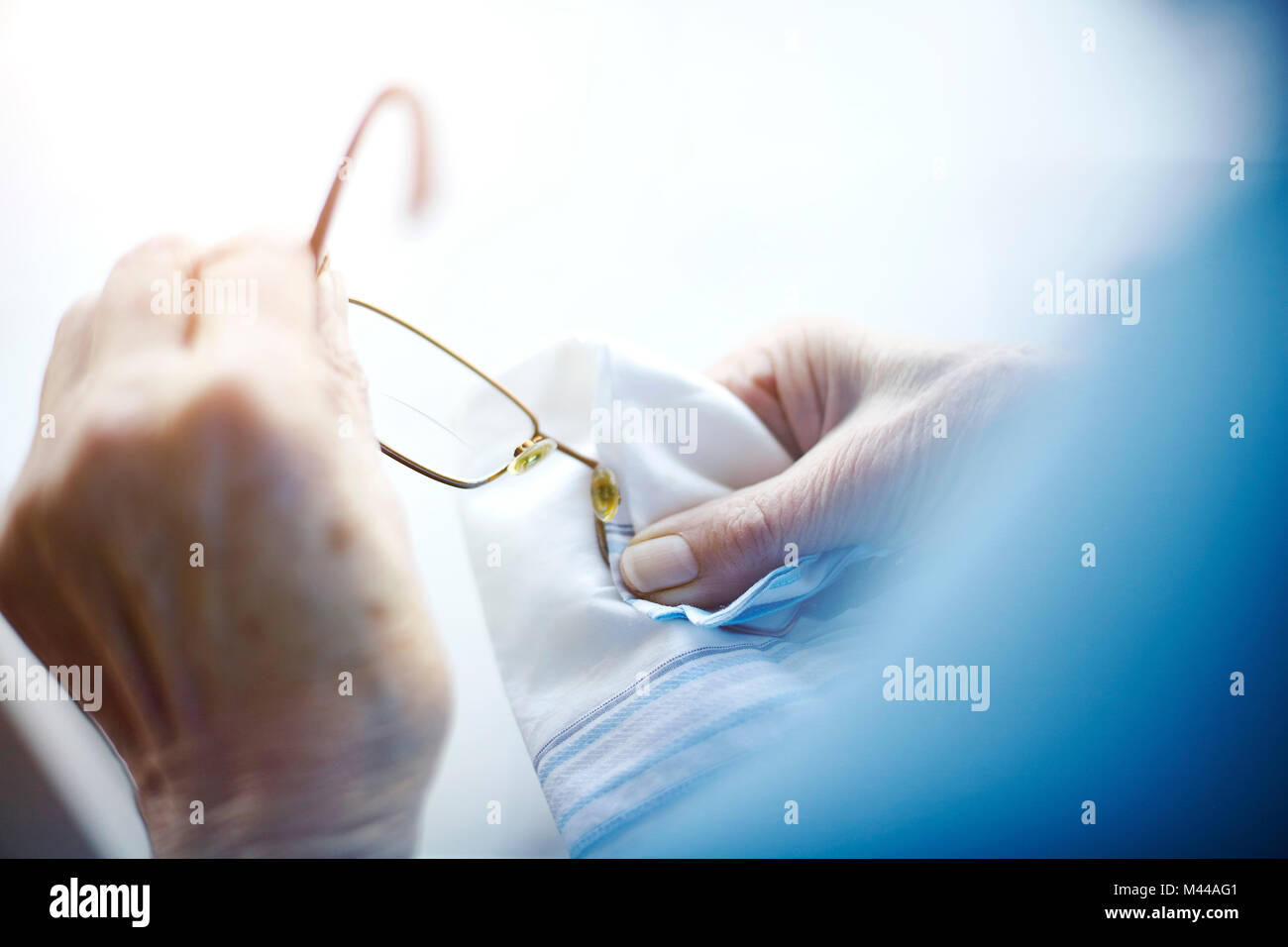 Senior woman cleaning eyeglasses with cloth, mid section Stock Photo ...